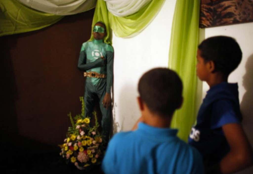 Kid Propped Up At His Wake With An XBox Controller, Doritos, And His ...